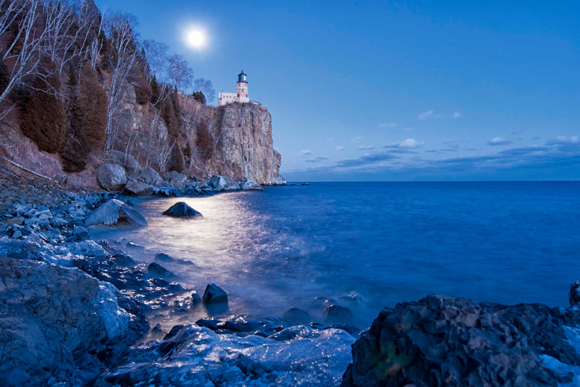 Lighthouse on Moonlit Cliff Overlooking the Tranquil Blue Ocean Horizon ...