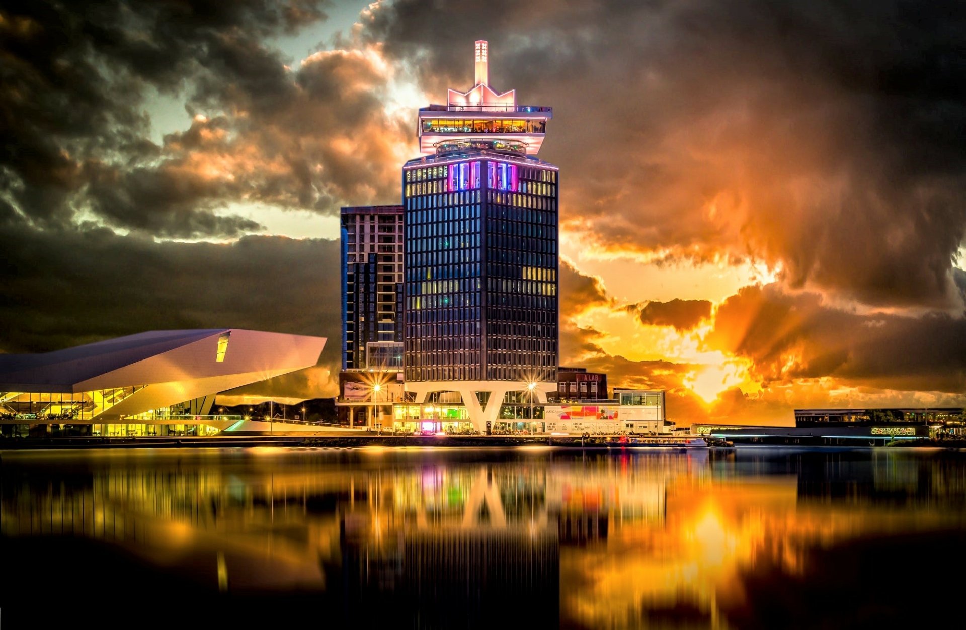 Amsterdam Nights: Illuminated Cityscape Under Dramatic Clouds